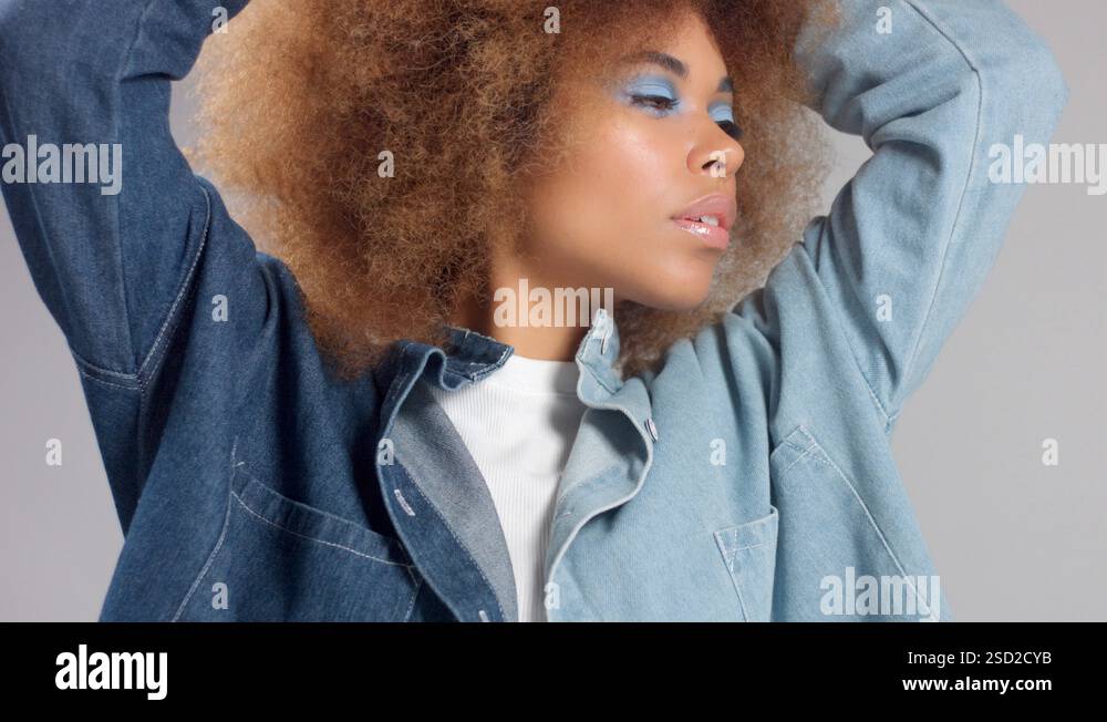 Mixed race black woman with big afro hair in denim style poses to a ...