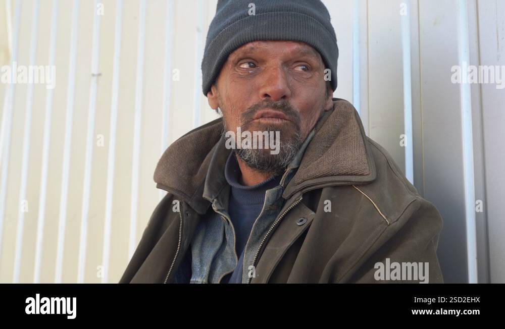 Homeless man laughing through tears during a conversation on the street ...