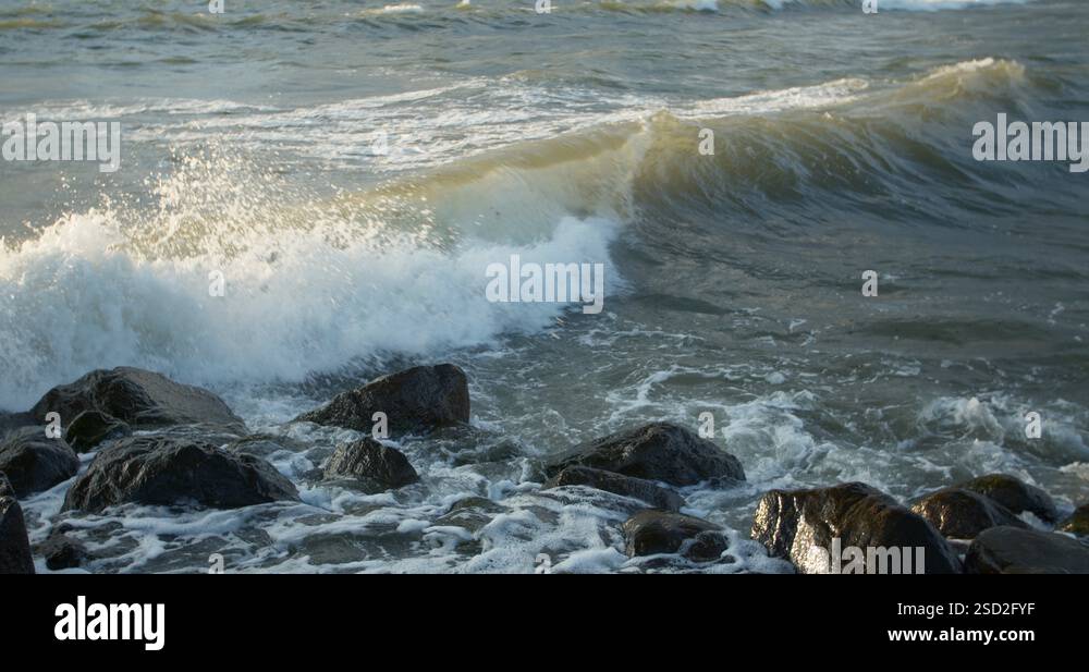 Waves rolling to the beach and crashing to the rocks in slow motion ...
