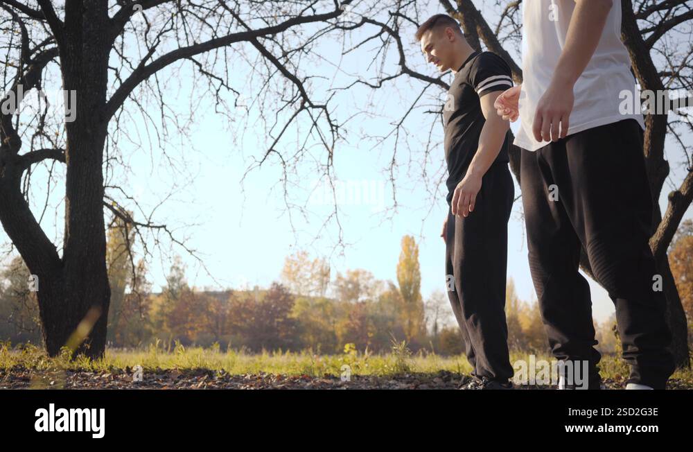 Two adult Caucasian boys stretching and standing on start line ...