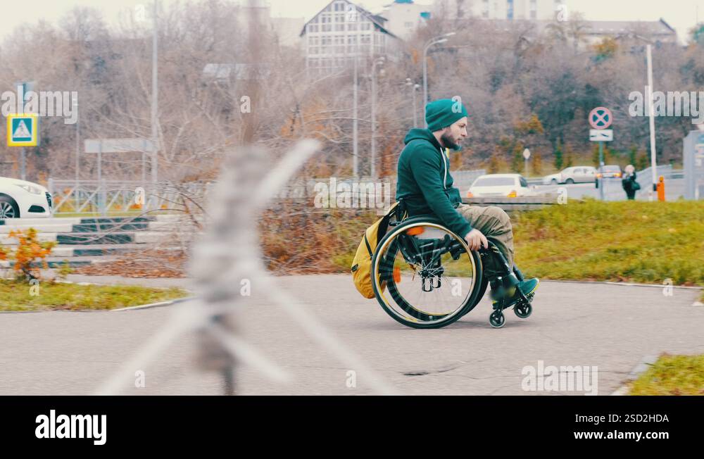 Disabled man in wheelchair makes attempt to steer his wheelchair over a ...