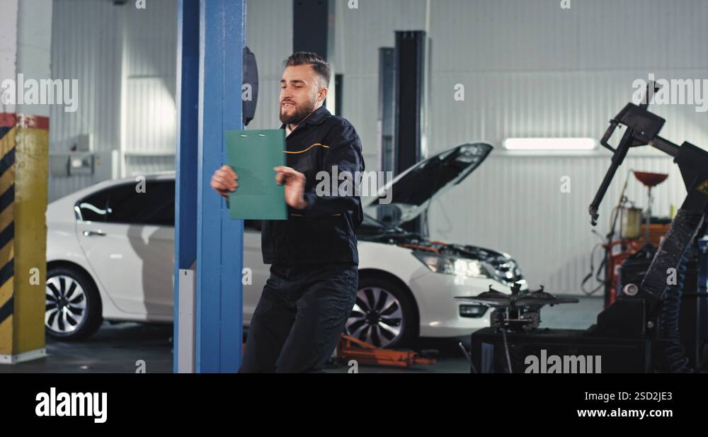 Dancing man mechanic in a service auto holding a map he are very ...