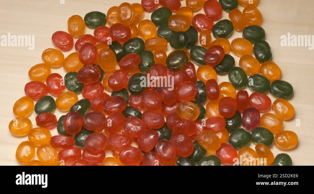 Many of sweets lie on rotating table, multi-colored sweets, caramel ...