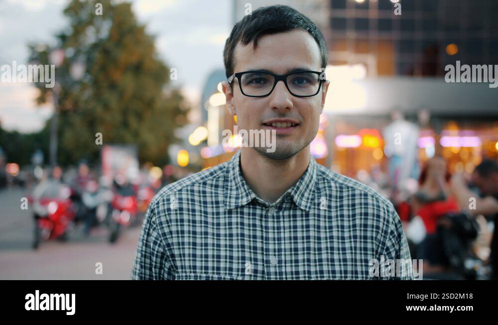 Happy guy in glasses smiling standing in pedestrian street in modern ...