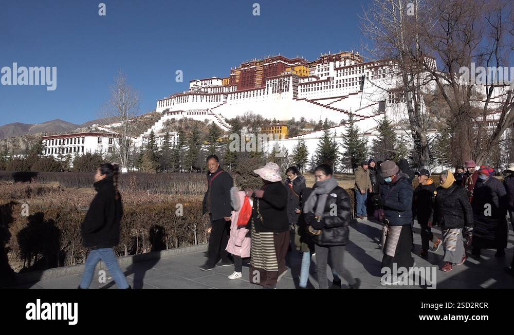 Tibetan pilgrims walk around Potala Palace in Lhasa during Winter Stock ...