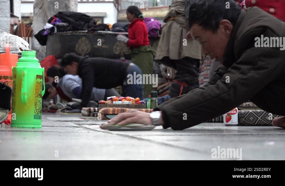 Tibetan Buddhist pilgrims perform religious prostrating ritual in Lhasa ...