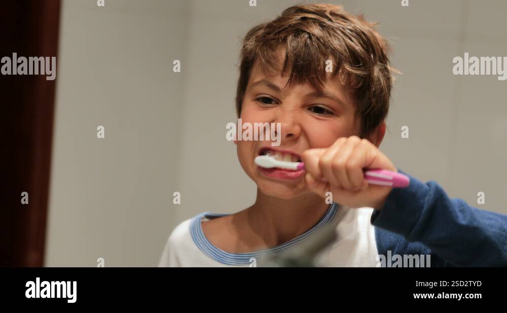 Child brushing teeth in front of mirror in 4K. Young boy brushes teeth ...