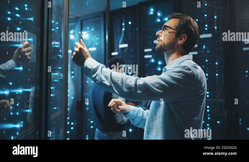 Server technician looking into rack server cabinets updating system ...