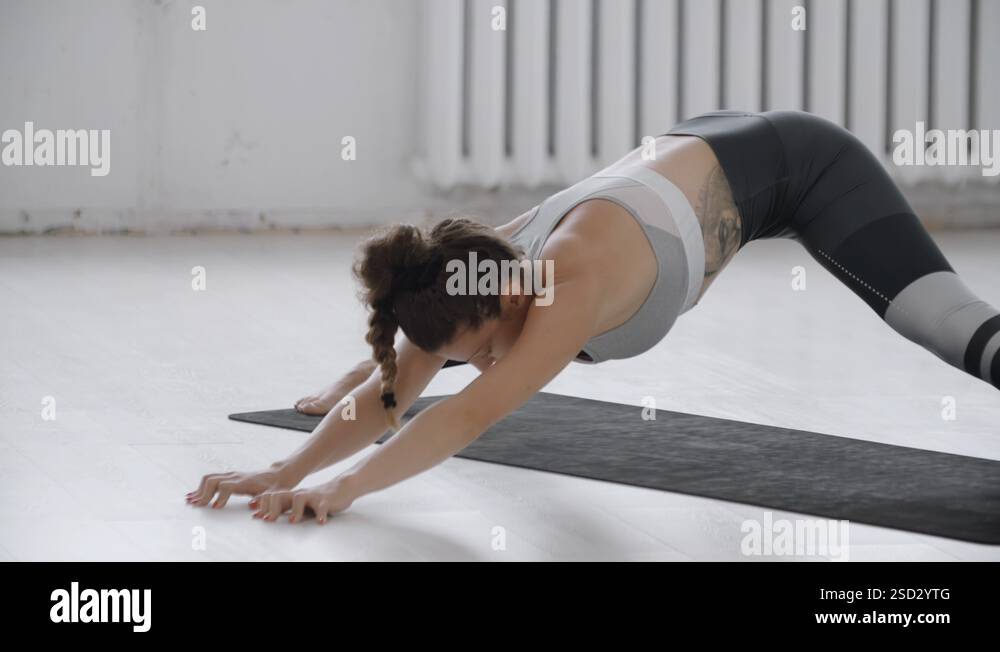 Flexible woman practice yoga and stretching exercises standing in twine on mat Stock Video ...