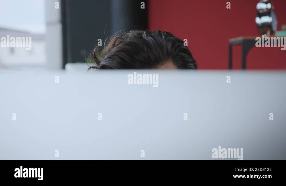 Close-up office supervisor spying his employees working hiding behind ...