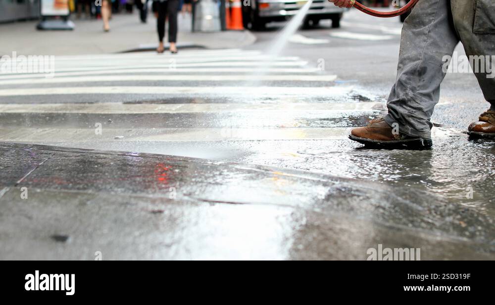 Cleaning city streets with water hose. Street sweeper cleaning asphalt ...