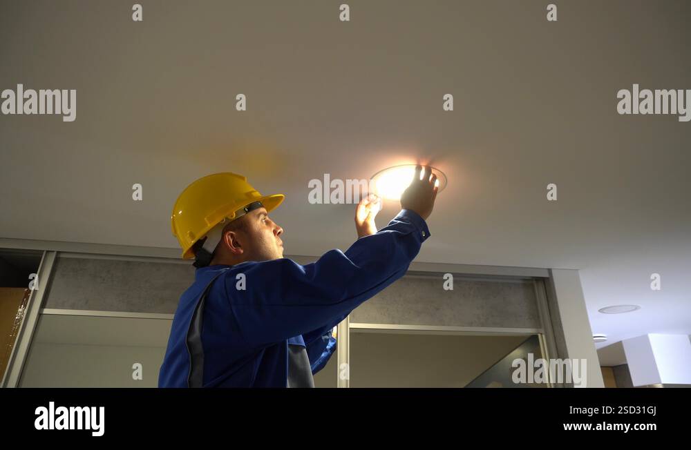 Electrician man remove led panel light from ceiling and inspect wire ...