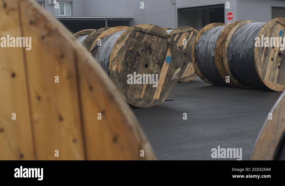 A lot of wooden spool of cable lying in the yard of the cable factory ...