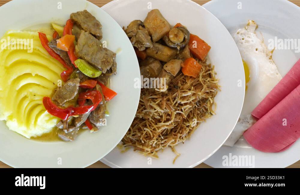 Several plates with various dishes rotates on the table. View from ...