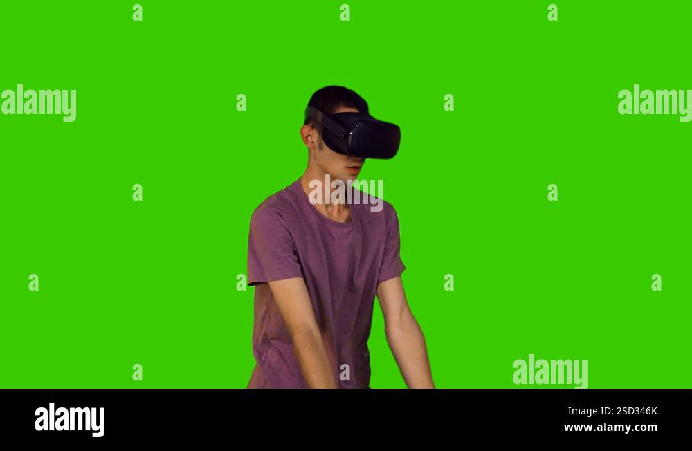 Slow motion, teenage boy with a VR headset playing over green screen ...
