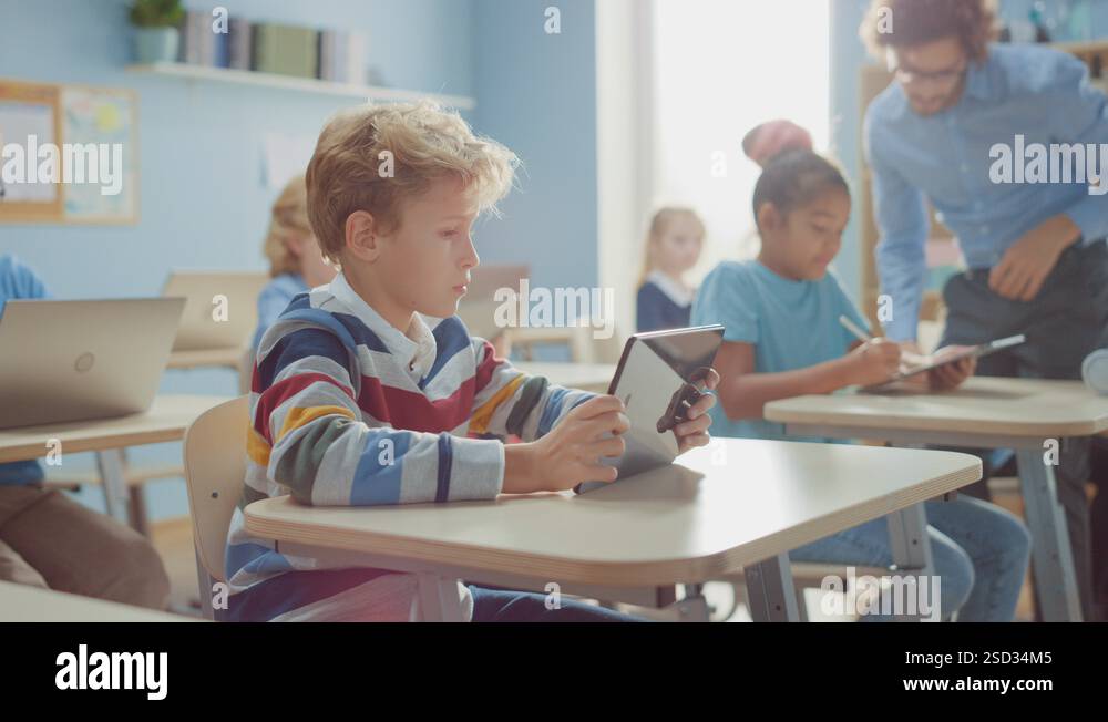 Elementary School Computer Science Class: Smart Boy Uses Digital Tablet ...