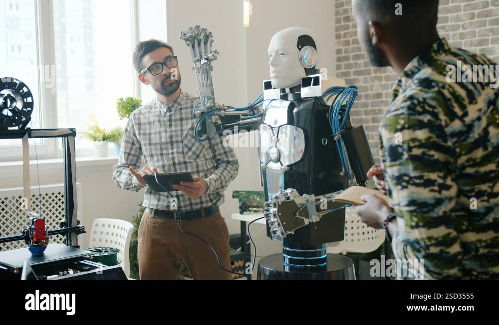 Guys testing cool robot in office with tablet, 3d printer working in ...