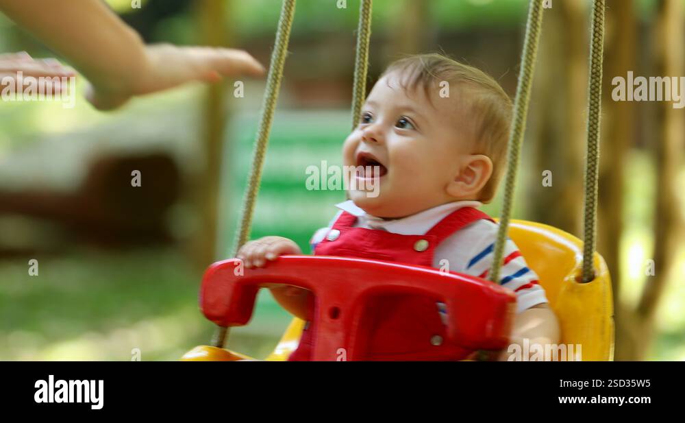 Mom pushing baby boy at playground park swing having fun enjoying with ...