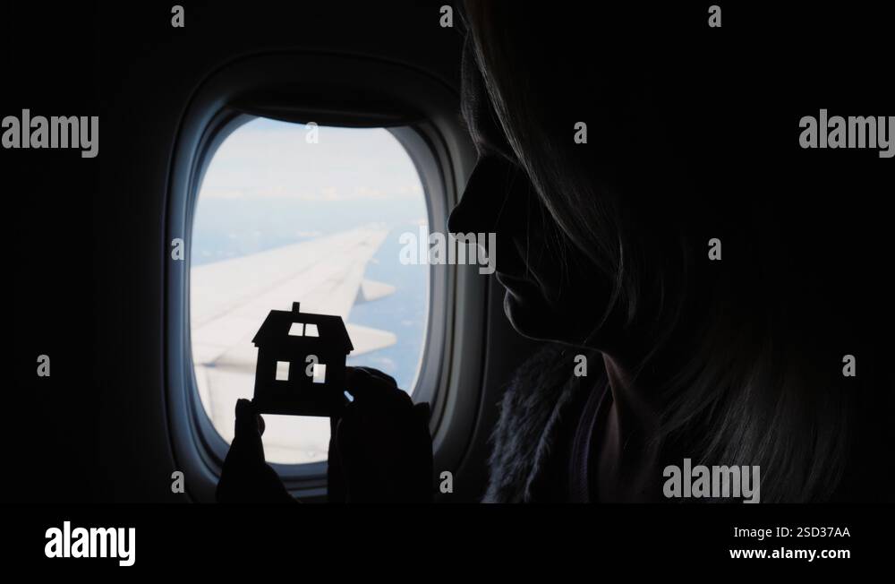 A woman is traveling by plane. Looks at the figure of the house in his ...