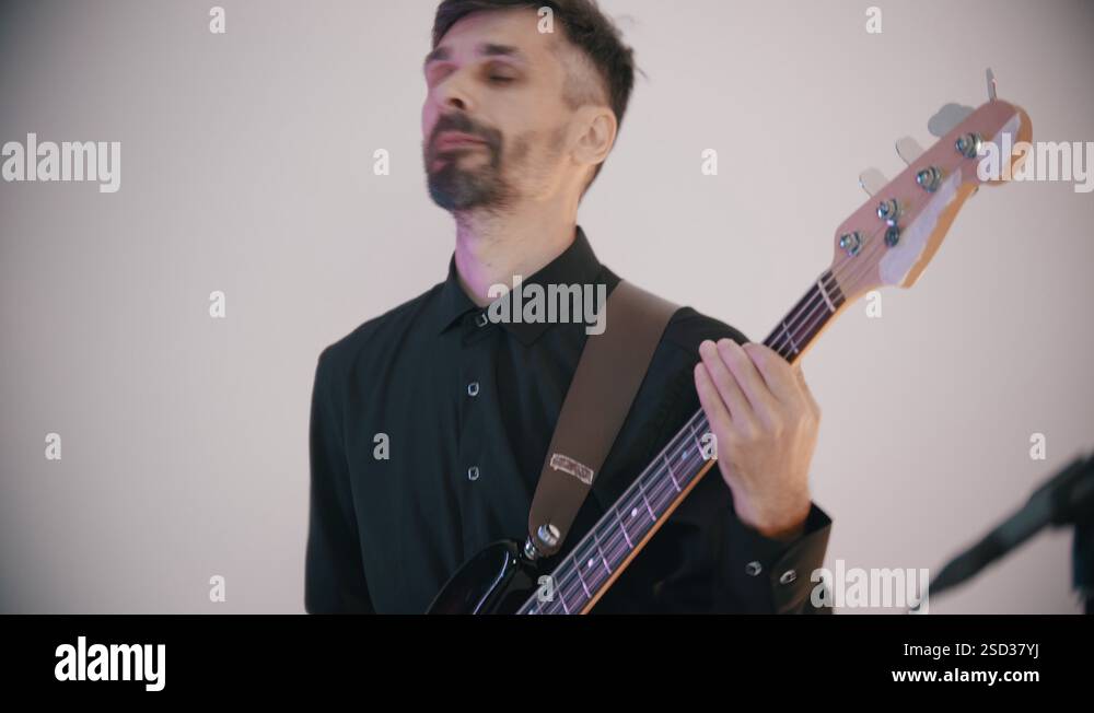 A musical band playing a song - a bassist playing his part and a woman ...