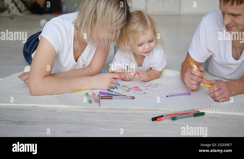 Happy family young parents paint with pencil and felt-tip pens, helping ...
