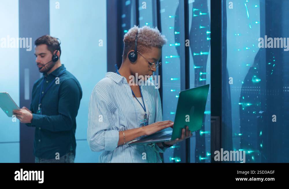 Black female IT engineer examining rack server cabinet in high tech ...
