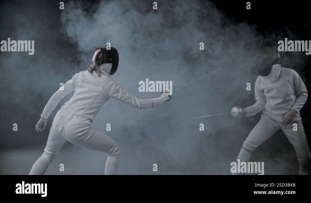 Fencing training - two women having a duel in the smoky studio Stock ...