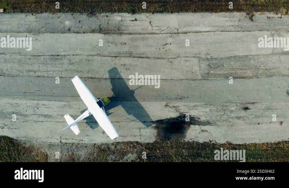 Worn runway with a small jet riding along it in a top view Stock Video ...
