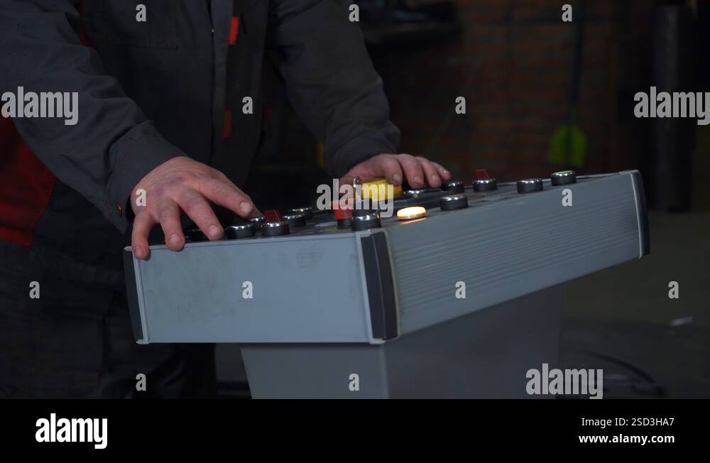 Worker in factory stand behind control panel, machine, dashboard ...