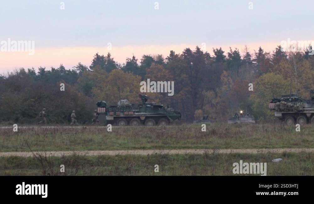 Soldiers running towards rear of Bradley Fighting Vehicle at dusk Stock ...