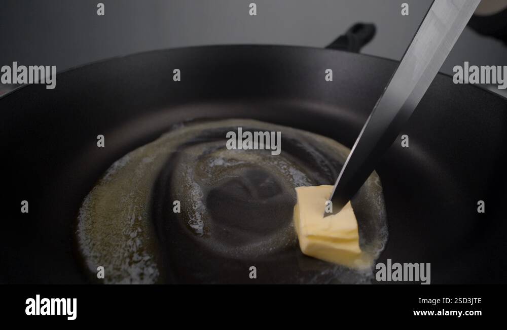 Chef greases the hot pan with butter, melting butter on the pan, butter ...
