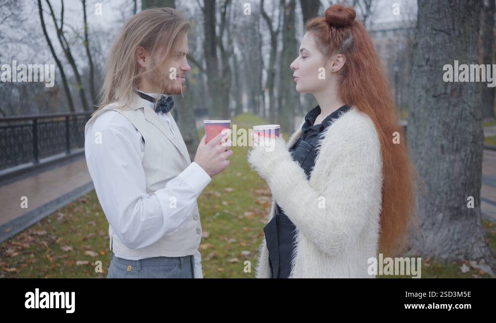 Side view of young Caucasian boyfriend and girlfriend standing face to ...