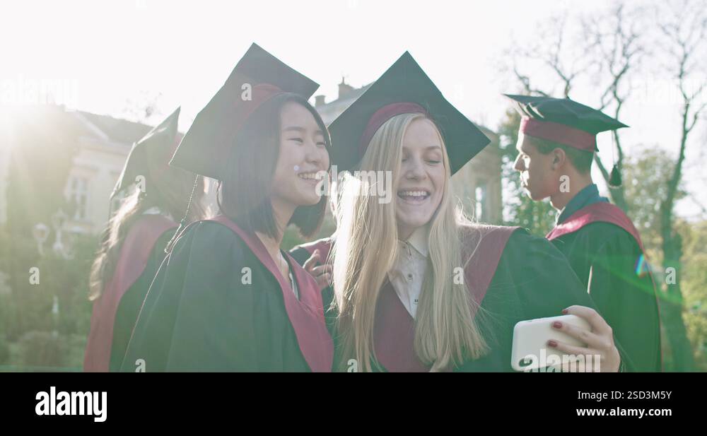 Mixed-races young beautiful girls, master students graduates smiling to ...