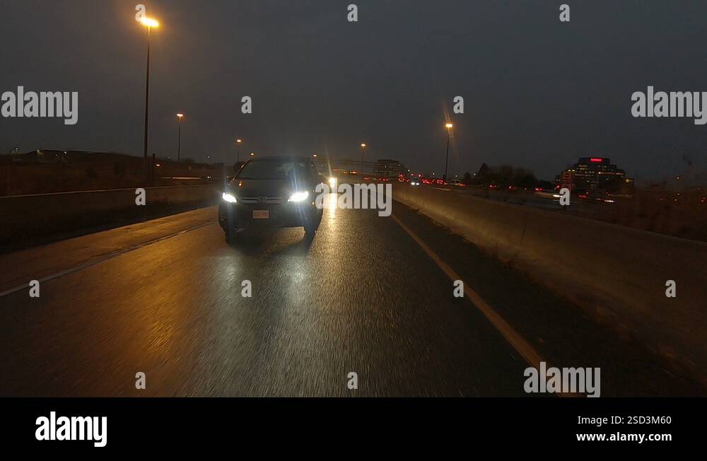 Driving plate rear view POV in the rain at night on streets with car ...