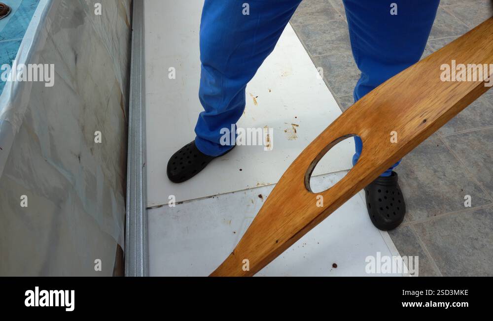 painter is painting varnishing oiling wood boards in oak color with ...