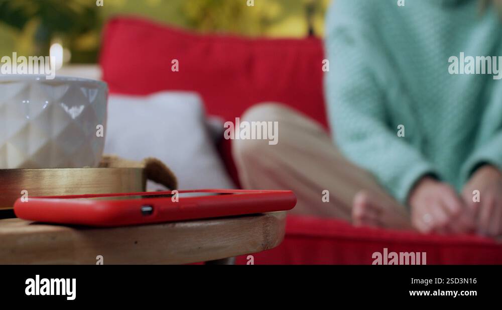 Scared woman housewife sitting on couch looking on smartphone calling ...