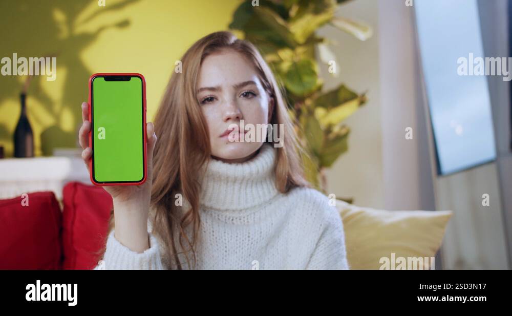 Attractive ginger girl holding vertical smartphone mockup chroma ...