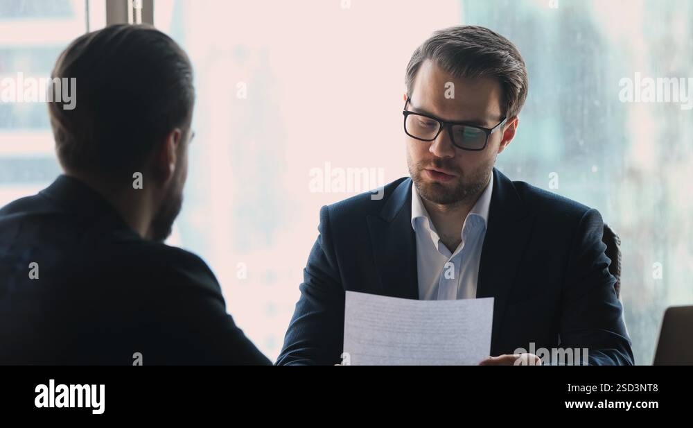 Serious businessman employer holding cv interviewing male job applicant ...