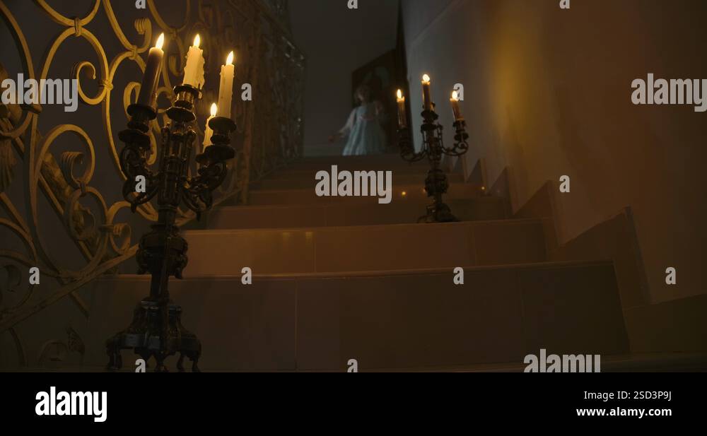 Bottom view of ladder with two candlesticks. Little Caucasian girl in ...