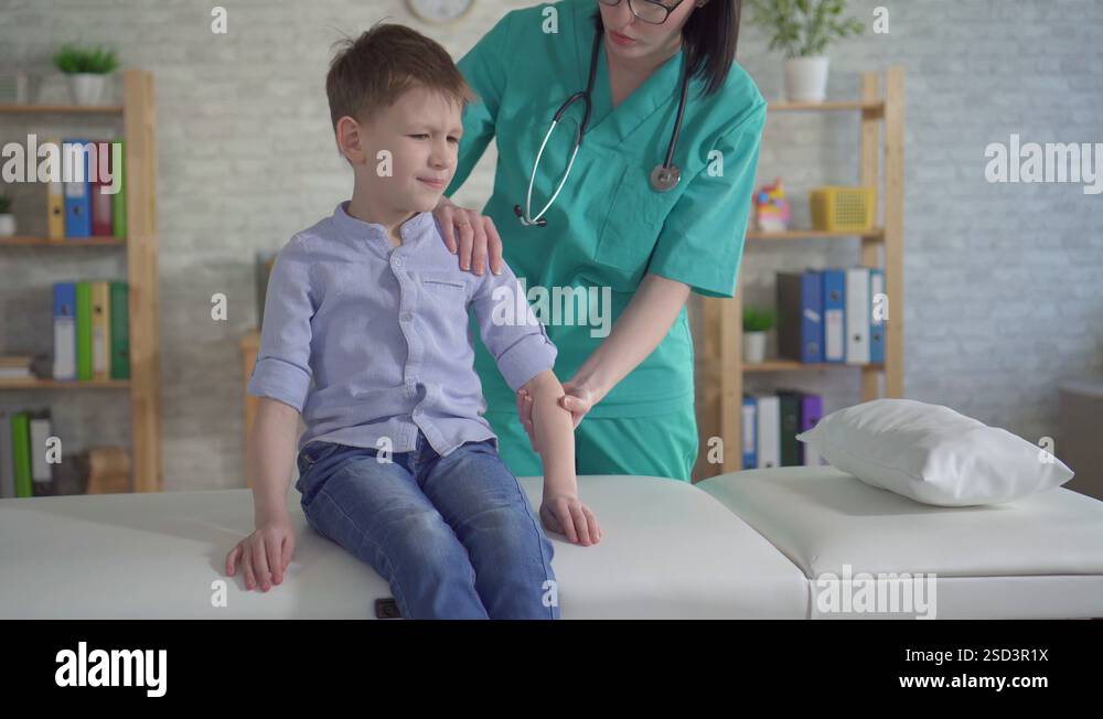 little boy with pain in his arm at a physiotherapist's appointment ...