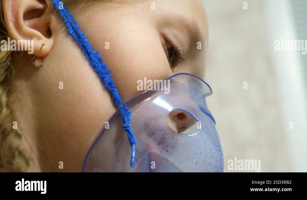 little girl treated with an inhalation mask on her face in hospital ...