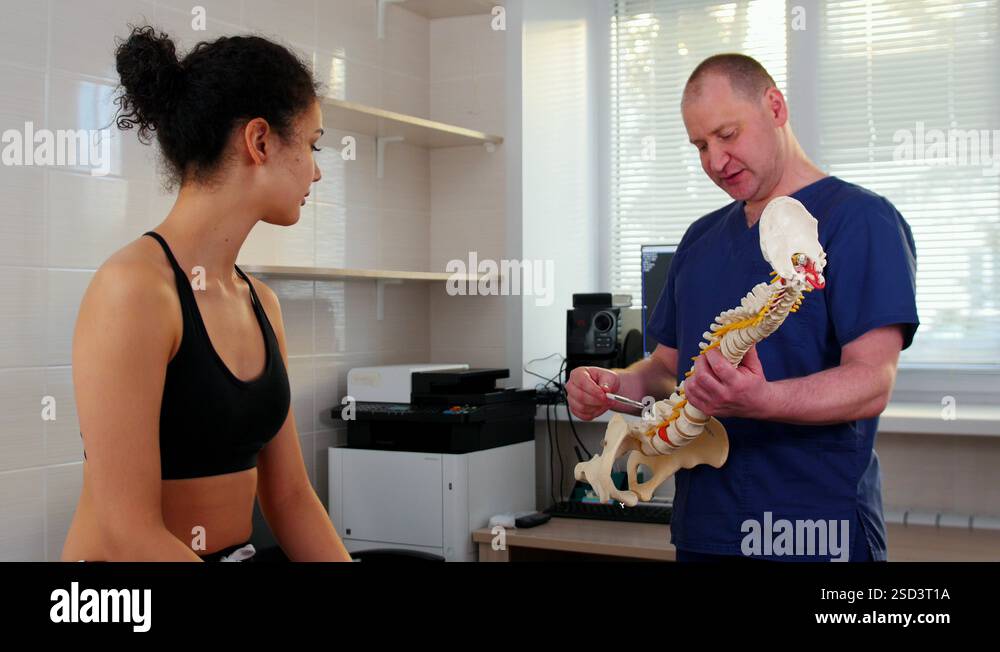 Chiropractic treatment - the doctor inspecting the young woman before the Stock Video Footage ...