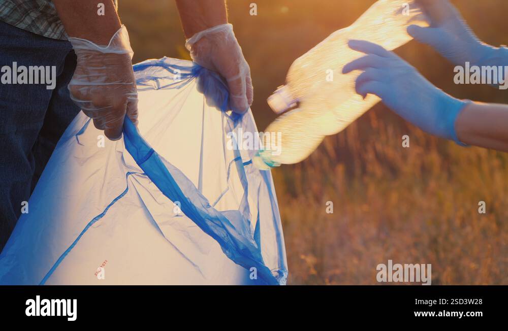 Volunteers put trash in plastic bags. Cleaning the park and caring for ...
