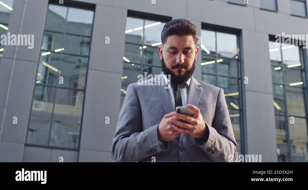 Caucasian handsome businessman with a beard typing and texting a ...
