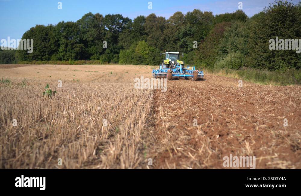 Agriculture machine discing stubble field. Walking toward tractor ...