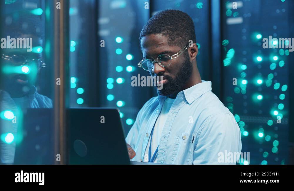 Smart young african engineer diagnosing hardware in rac server cabinet ...