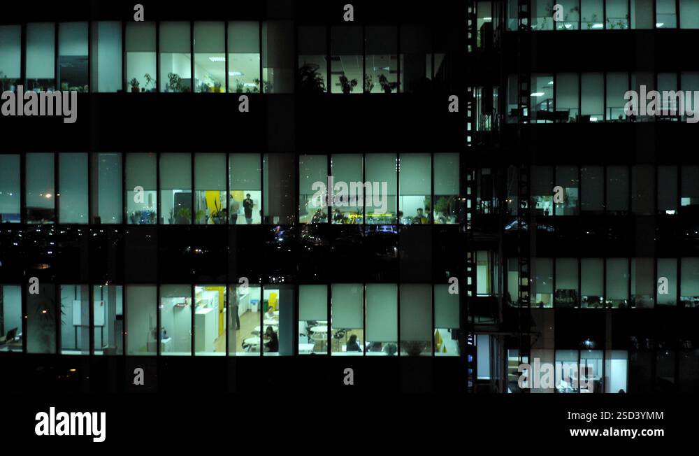 Aerial view of the skyscraper windows with a lot of office people ...