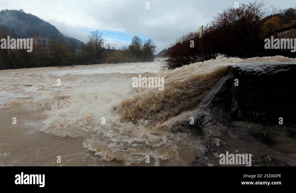 Slow motion low angle flooding dirty turbulent water flowing over ...