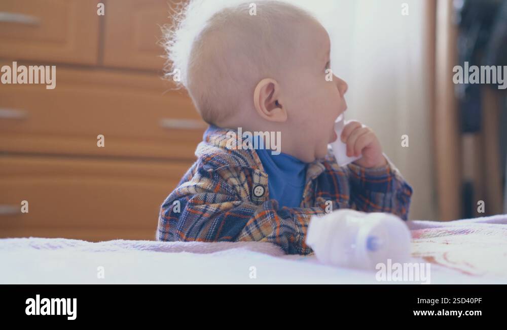 little boy nibbles part of inhaler standing near bed closeup Stock ...