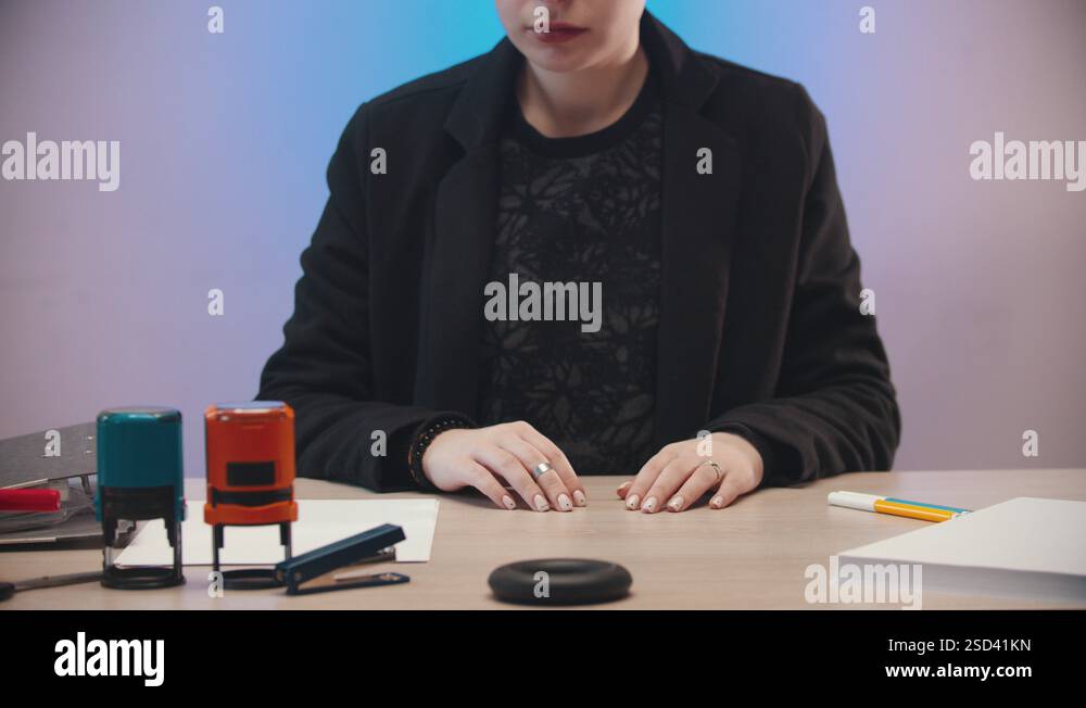 office - a woman is taking documents from a man putting a stamp on them ...